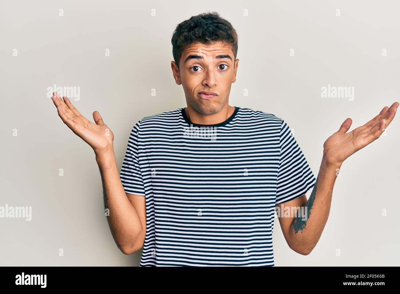 Young handsome african american man wearing casual clothes clueless and ...