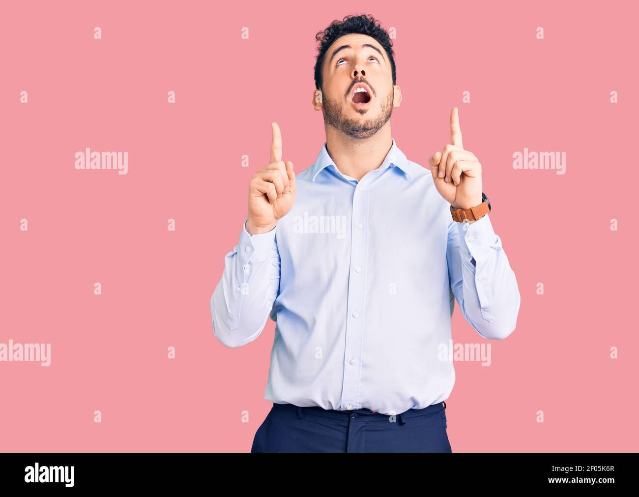 Young hispanic man wearing business clothes amazed and surprised ...