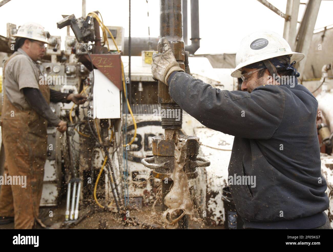 Rig workers change out drill pipe on a rig in Anthony, Kansas, in ...