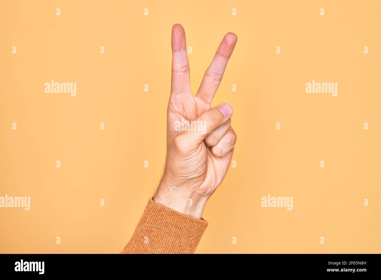 Hand of caucasian young man showing fingers over isolated yellow ...