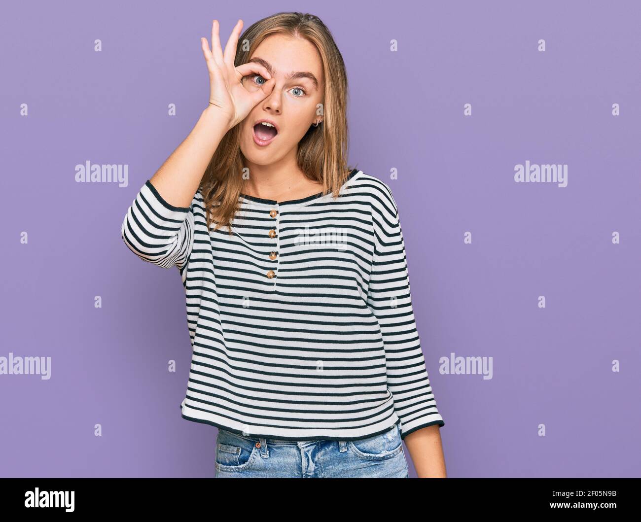Beautiful blonde woman wearing casual clothes doing ok gesture shocked ...