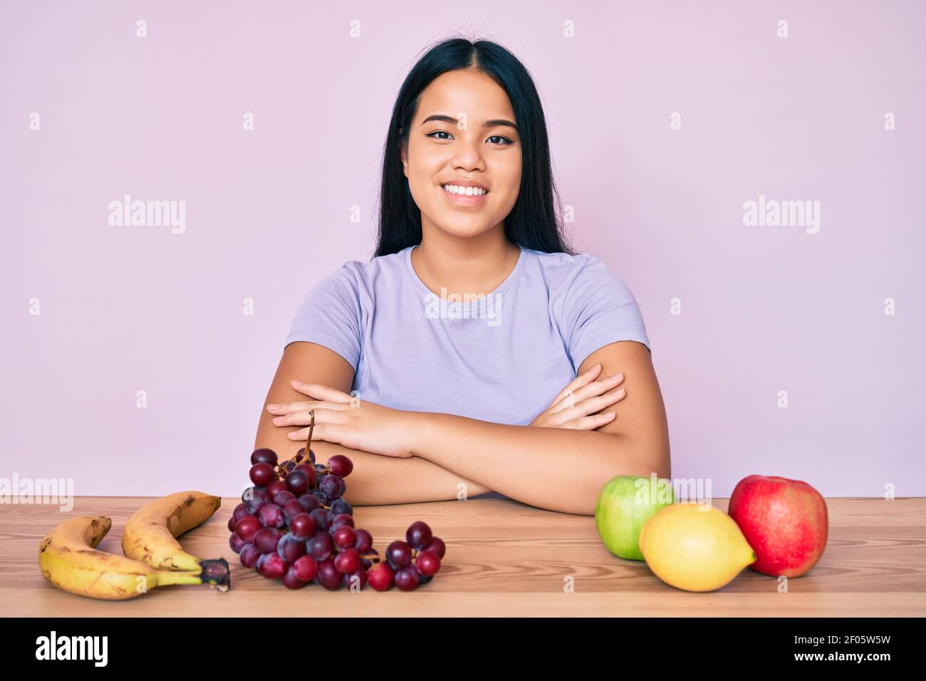 Young beautiful asian girl eating fresh and healthy fruit happy face ...