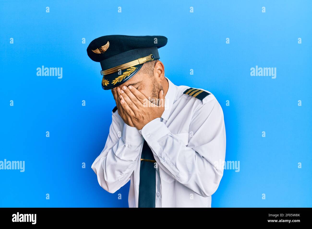 Handsome man with beard wearing airplane pilot uniform with sad ...
