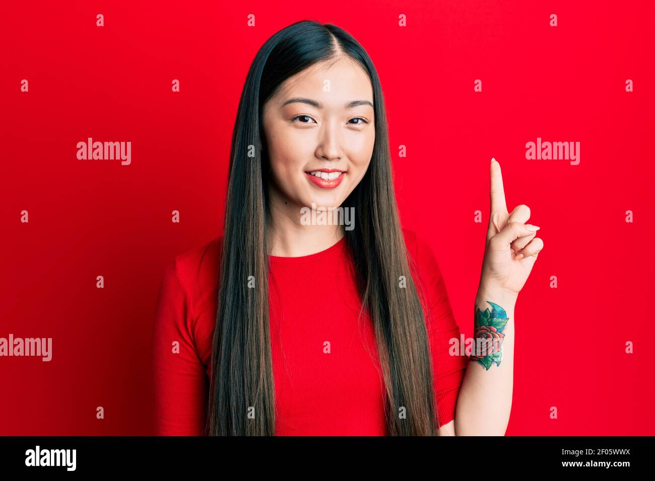 Young chinese woman wearing casual clothes smiling with an idea or ...