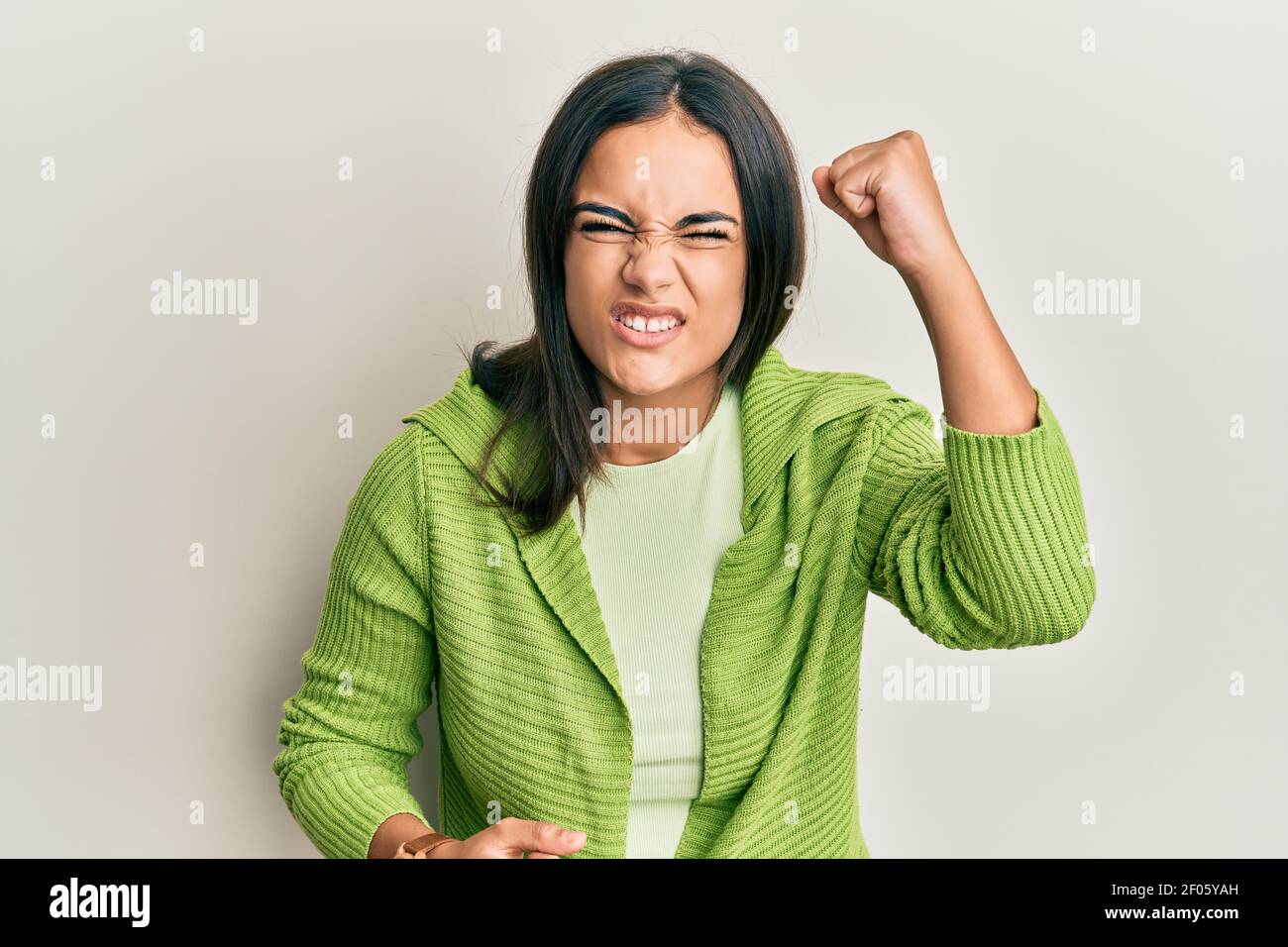 Young brunette woman wearing casual clothes angry and mad raising fist ...