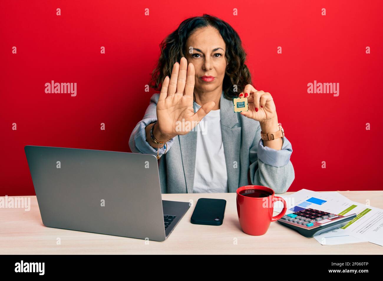 Beautiful middle age woman holding cpu computer processor with open ...