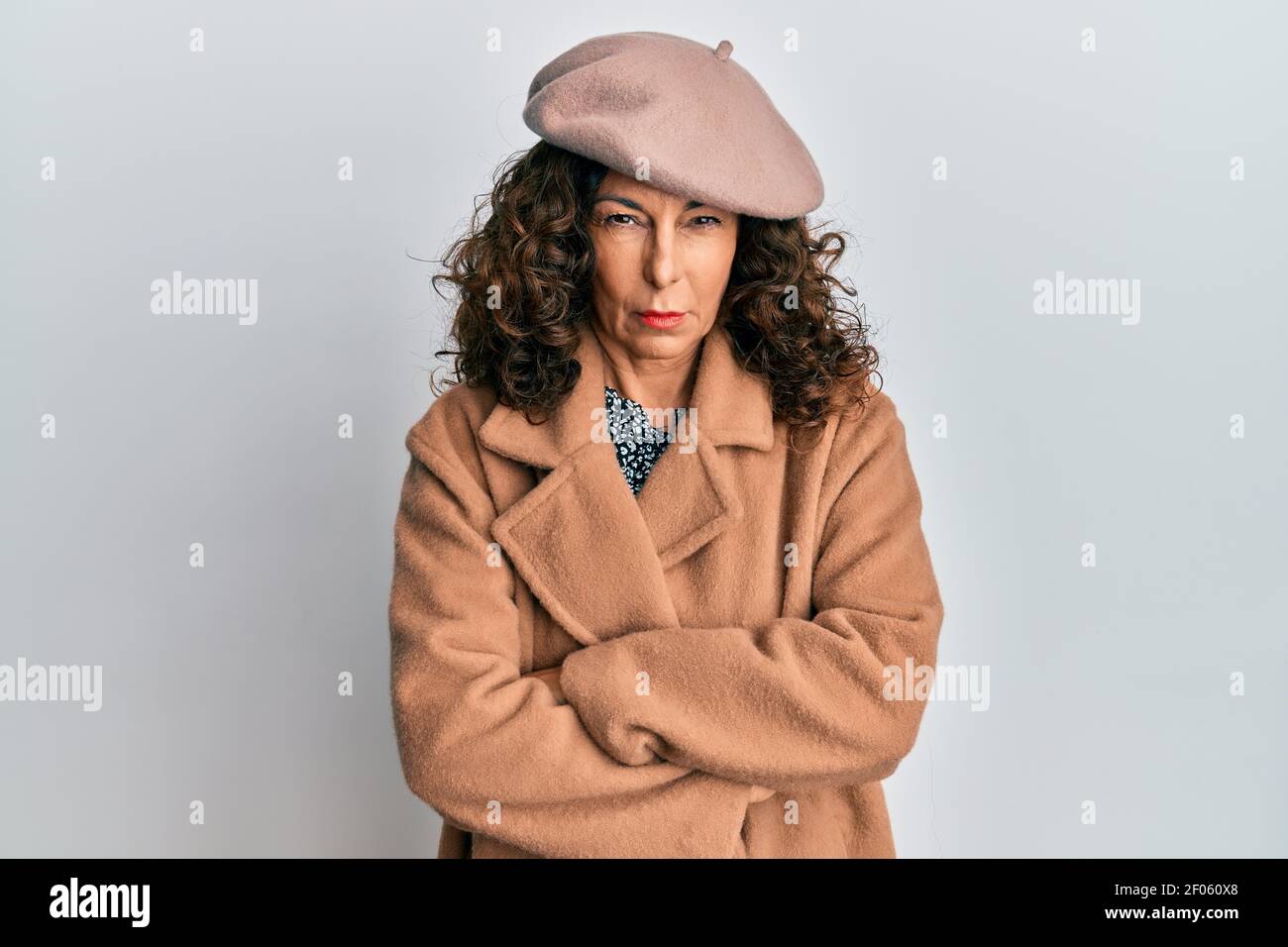 Middle age hispanic woman wearing french look with beret skeptic and ...