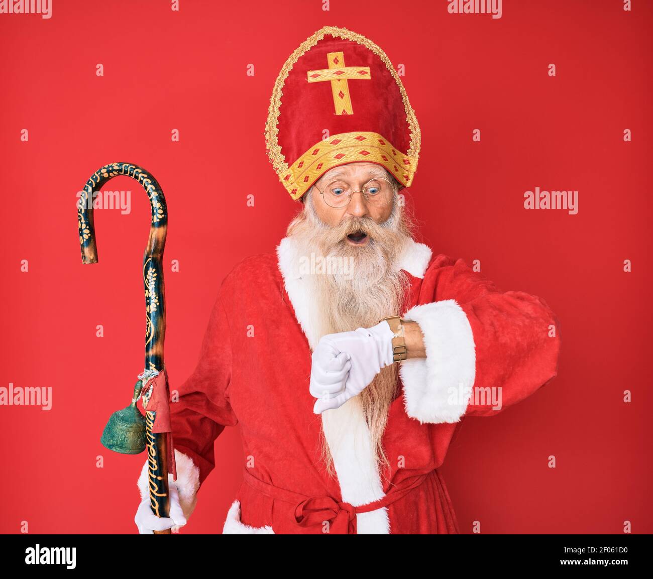 Old senior man with grey hair and long beard wearing traditional saint ...