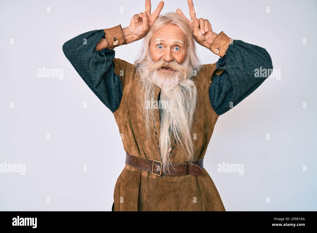Old senior man with grey hair and long beard wearing viking traditional ...
