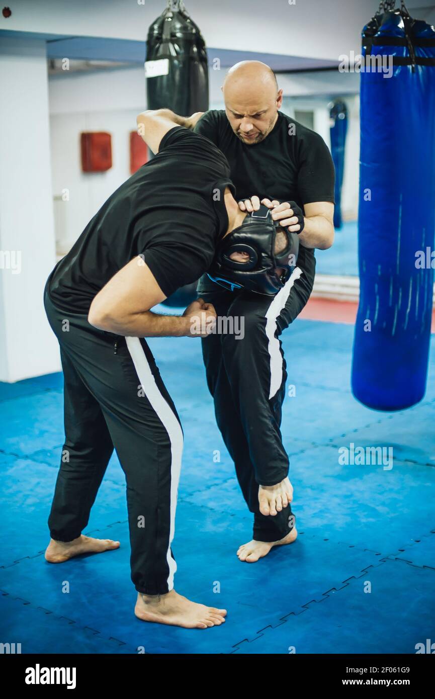 Instructor demonstrate knee kick street fight technique against ...
