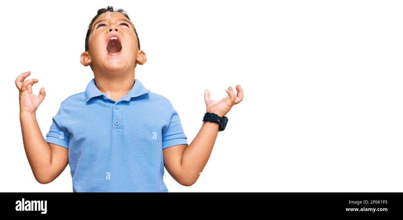 Little boy hispanic kid wearing casual clothes crazy and mad shouting ...