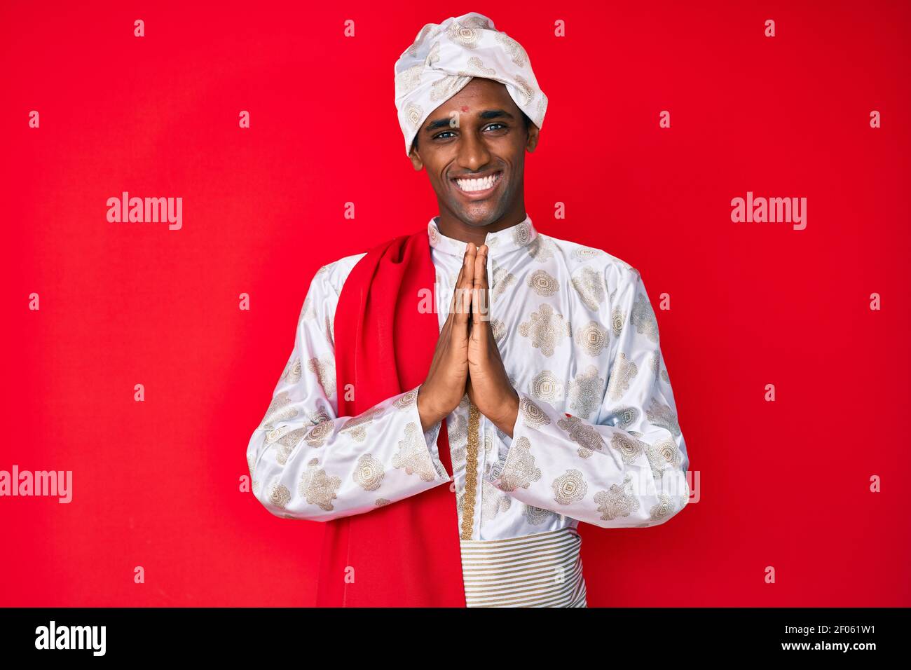 Handsome indian man wearing tradition sherwani saree clothes praying ...