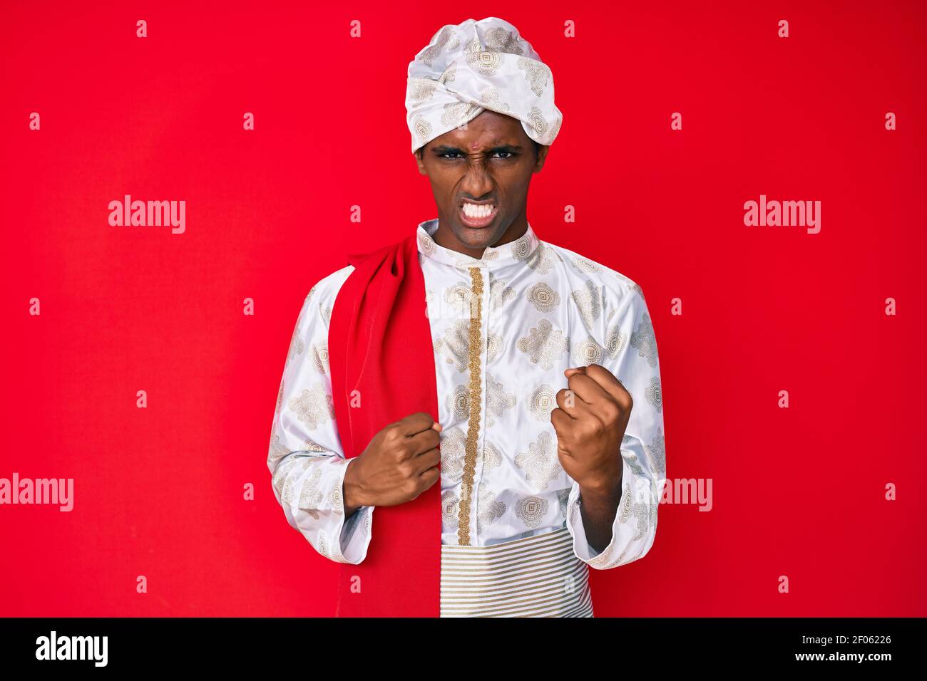 Handsome indian man wearing tradition sherwani saree clothes angry and ...