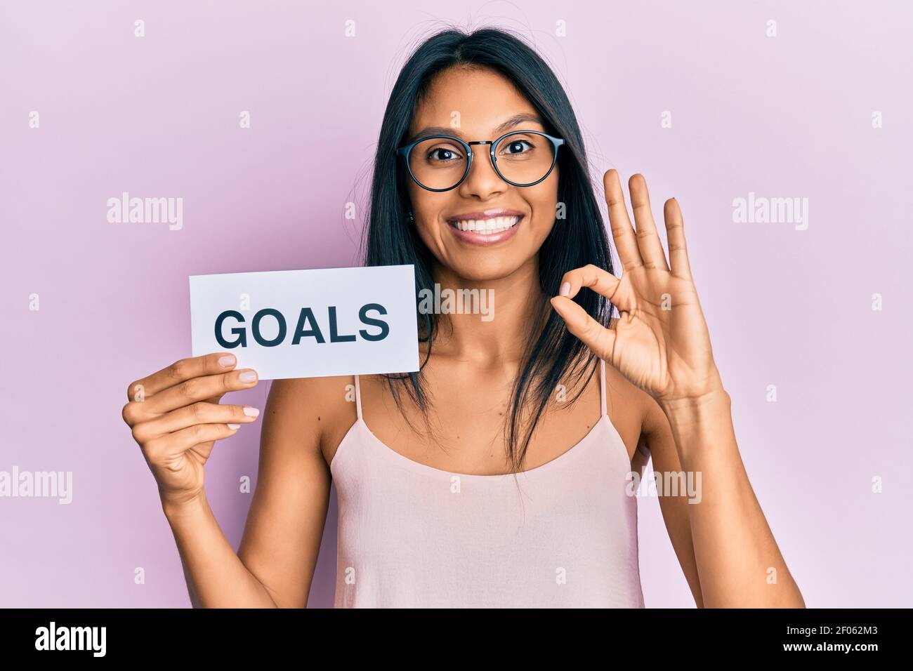 Young african american woman holding goals message paper doing ok sign ...