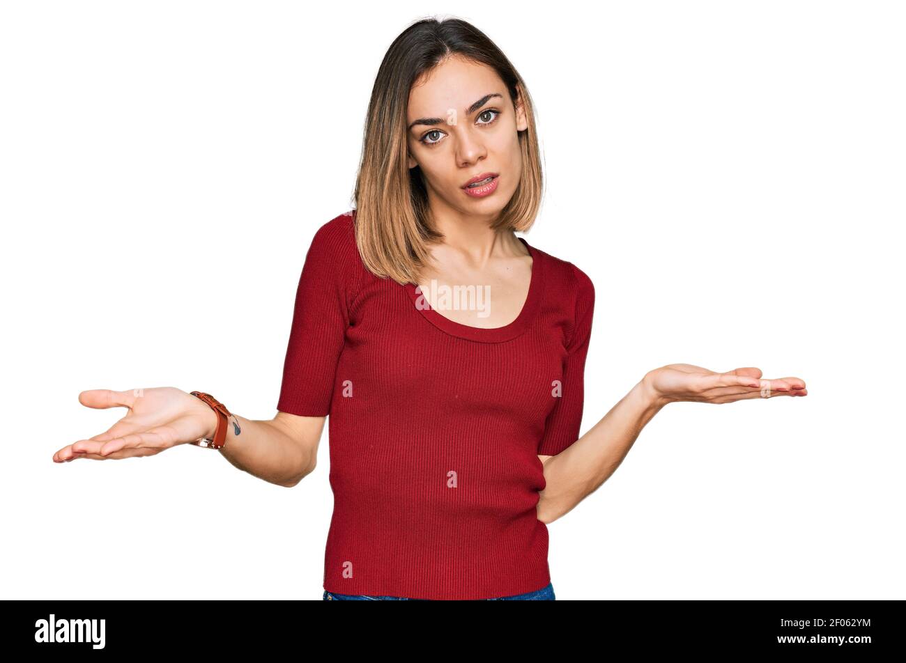 Young blonde girl wearing casual clothes clueless and confused with ...