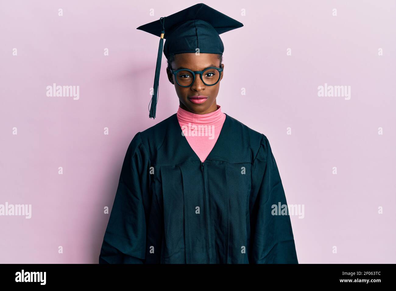 Young african american girl wearing graduation cap and ceremony robe ...