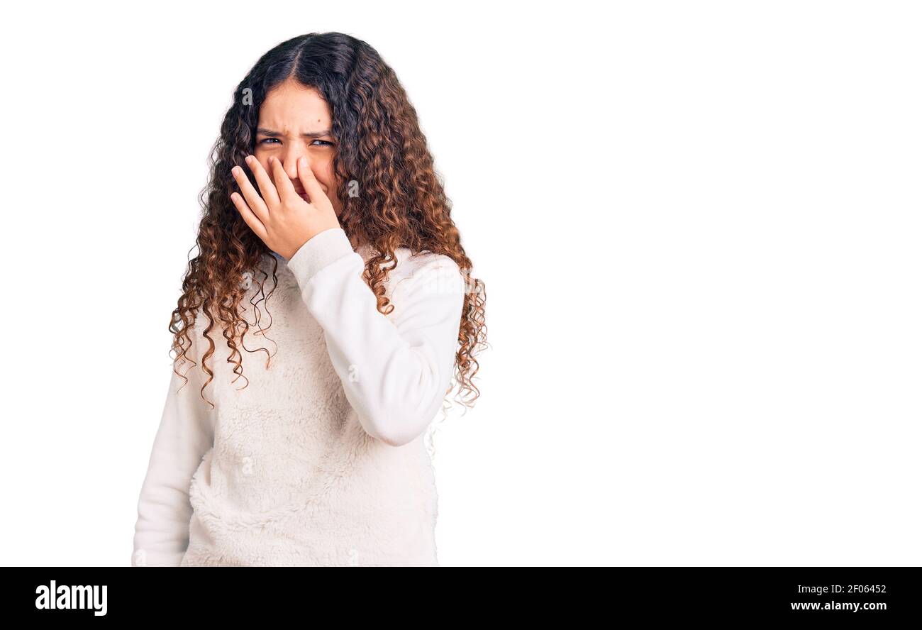 Beautiful kid girl with curly hair wearing casual clothes smelling ...