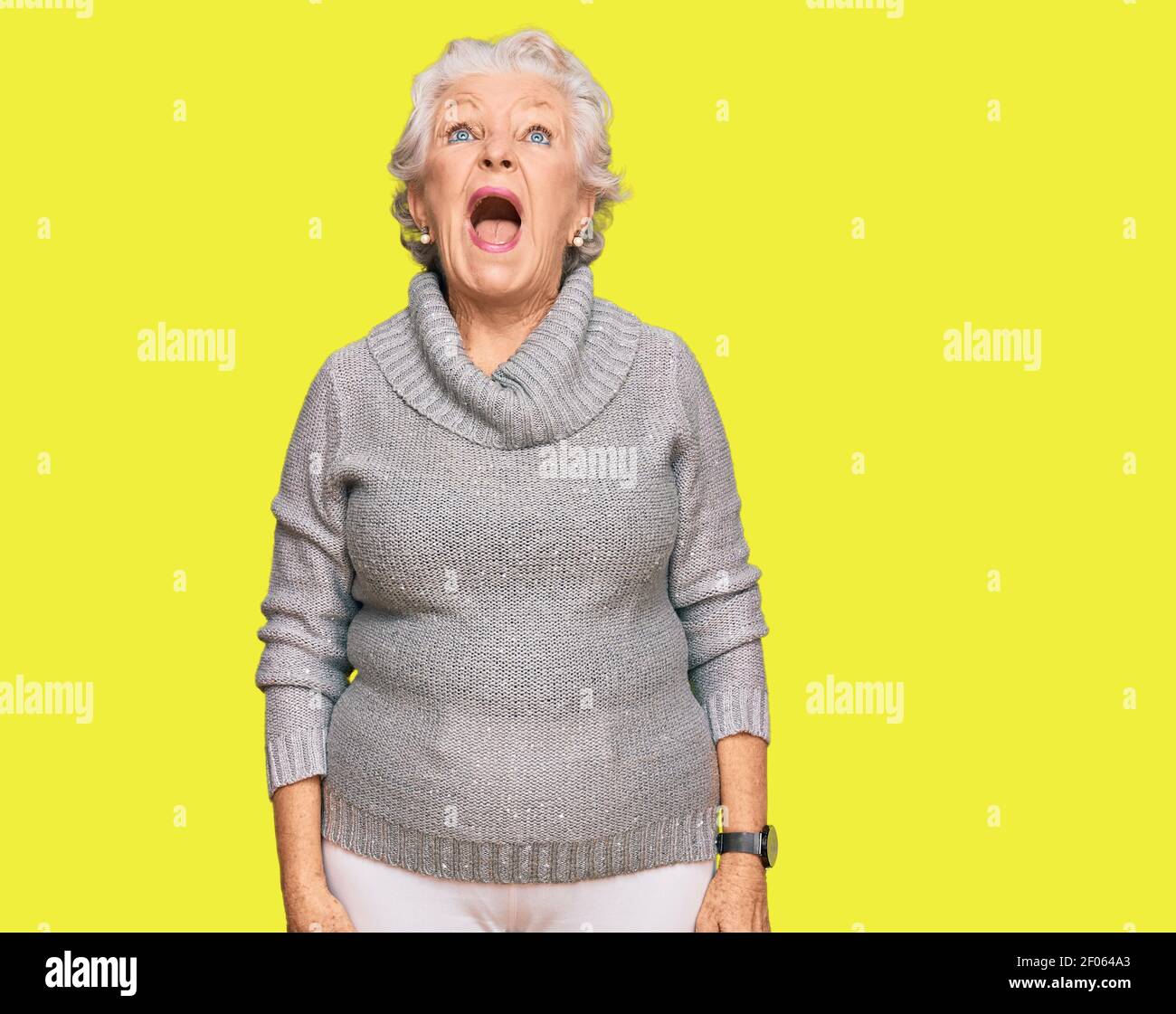 Senior grey-haired woman wearing casual winter sweater angry and mad ...
