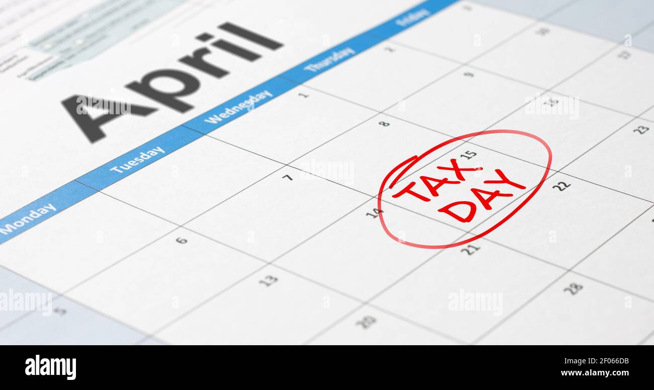 Writing tax day on April 15 calendar with red marker. Deadline for 1040 ...