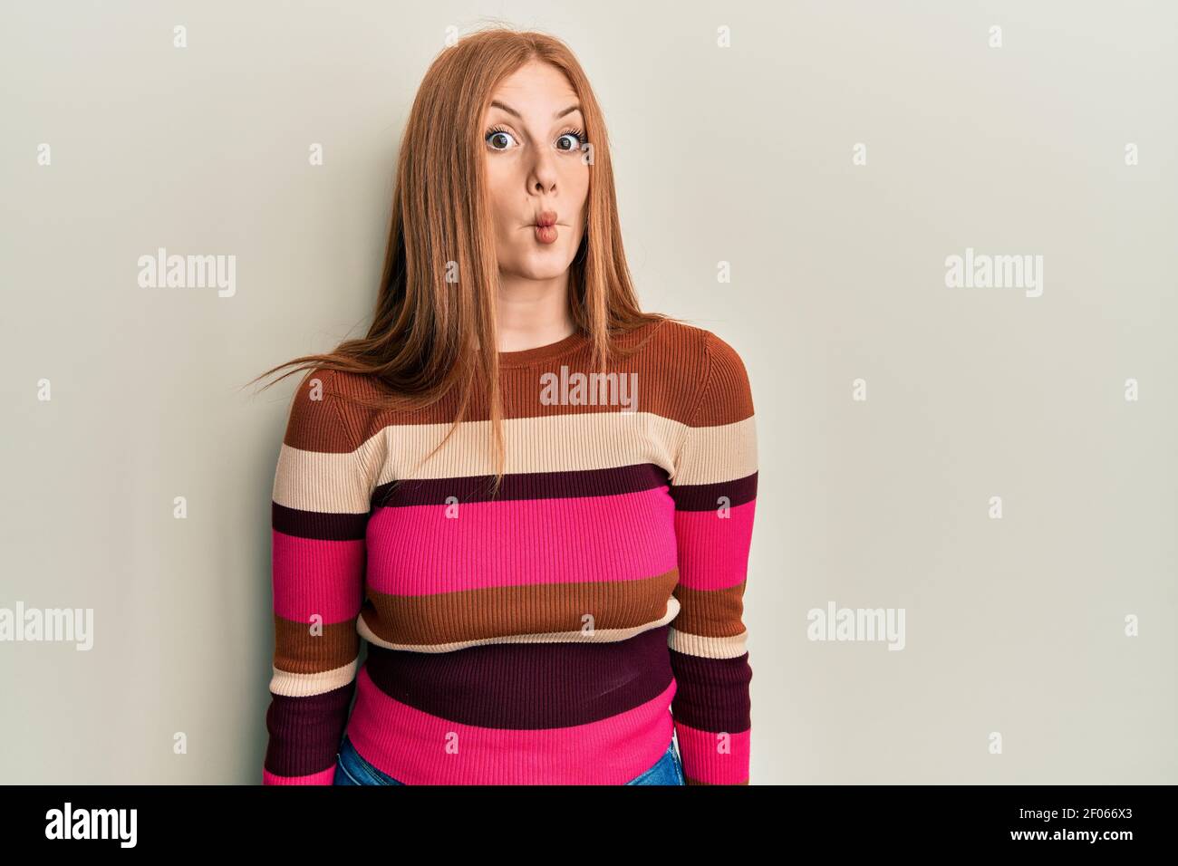 Young irish woman wearing casual clothes making fish face with lips ...
