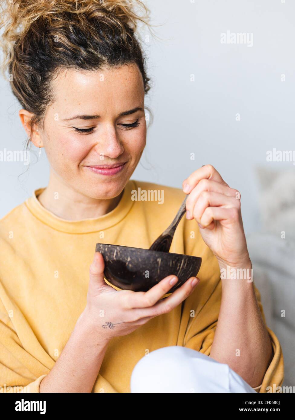Young blonde cheerful Woman in casual clothes eating healthy food from ...