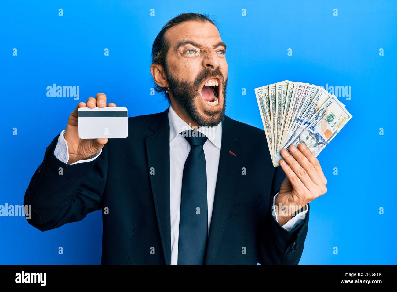 Attractive business man with long hair and beard holding credit card ...