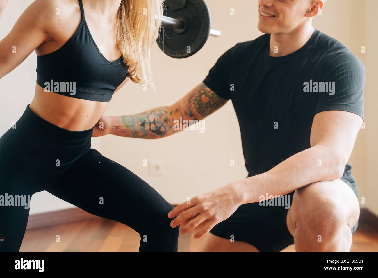 Strong Woman in black activewear doing barbell back squat exercise with ...