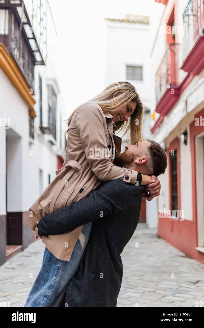 Side view of content boyfriend lifting girlfriend while standing in ...