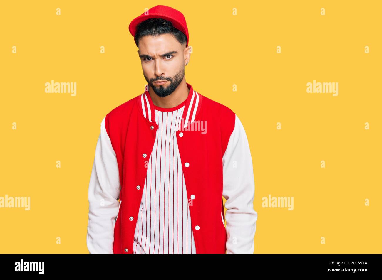 Young man with beard wearing baseball uniform skeptic and nervous ...