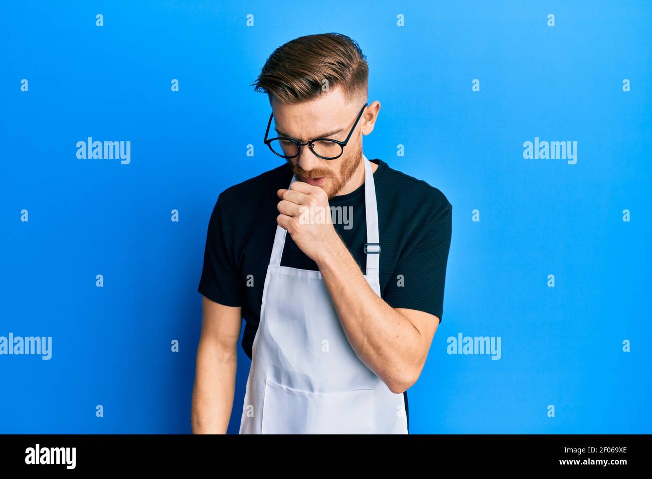 Young redhead man wearing professional apron feeling unwell and ...