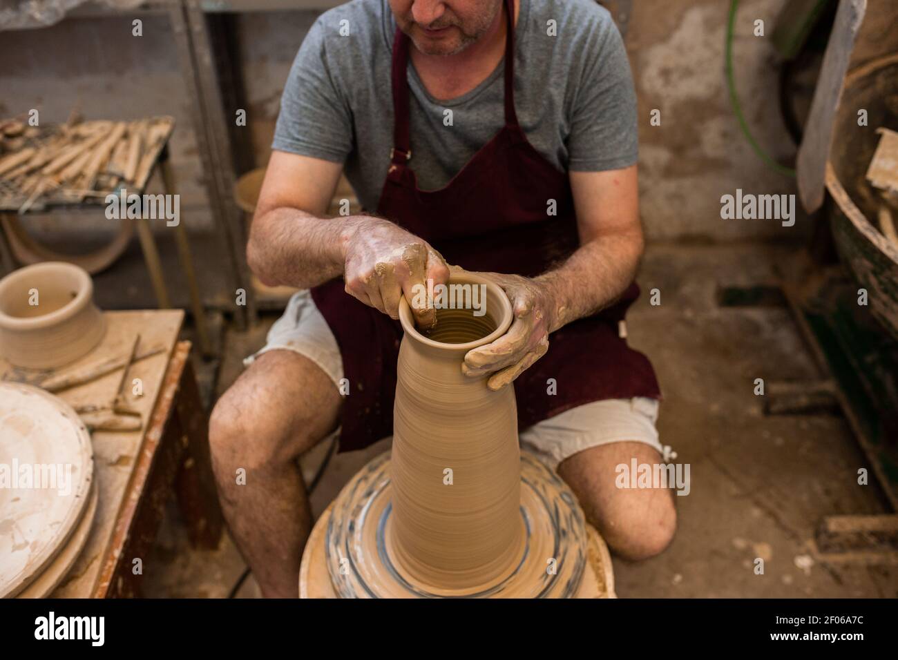 Crop unrecognizable sculptor with equipment giving shape while ...