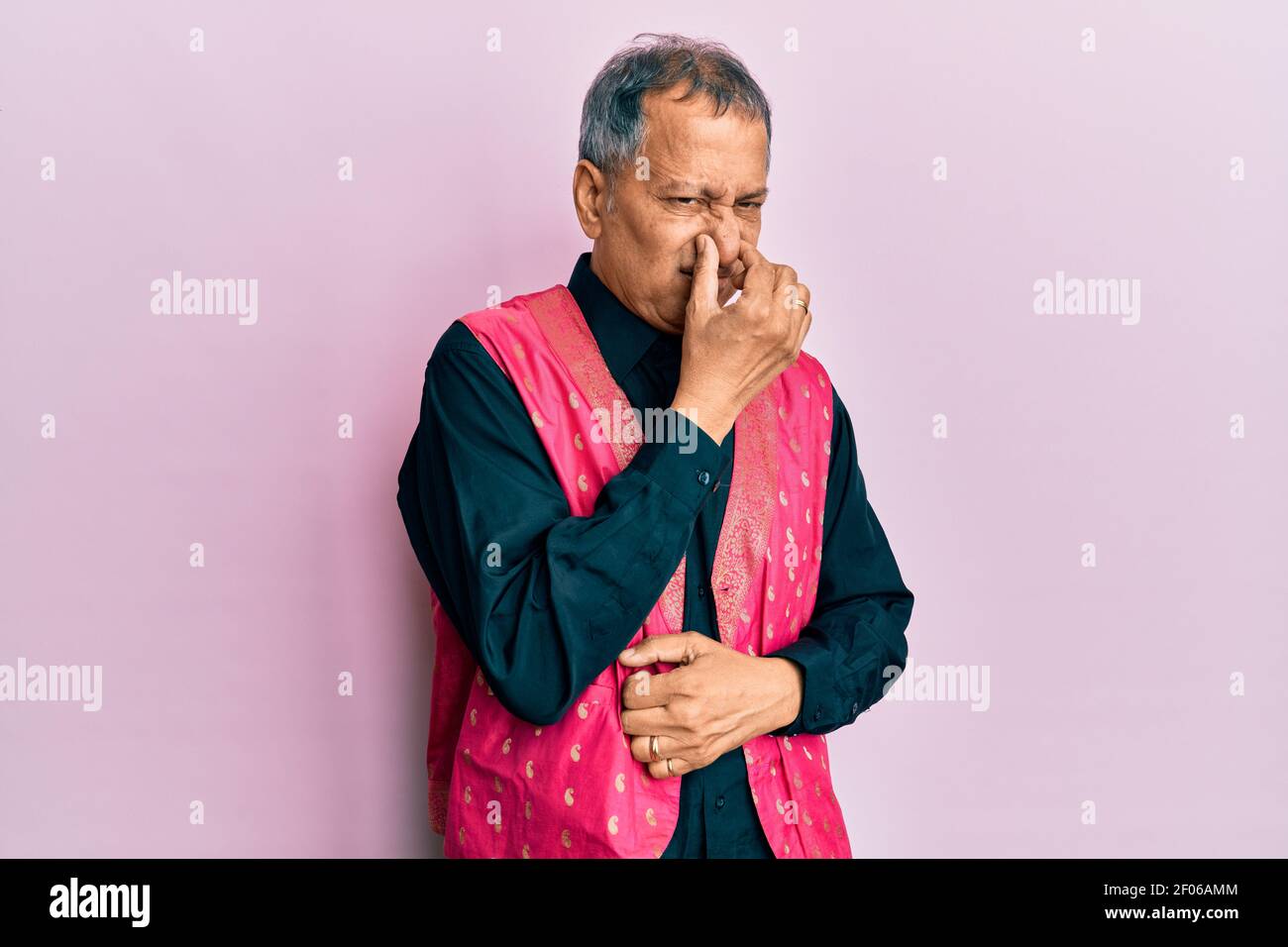 Middle age indian man wearing traditional indian clothes smelling ...