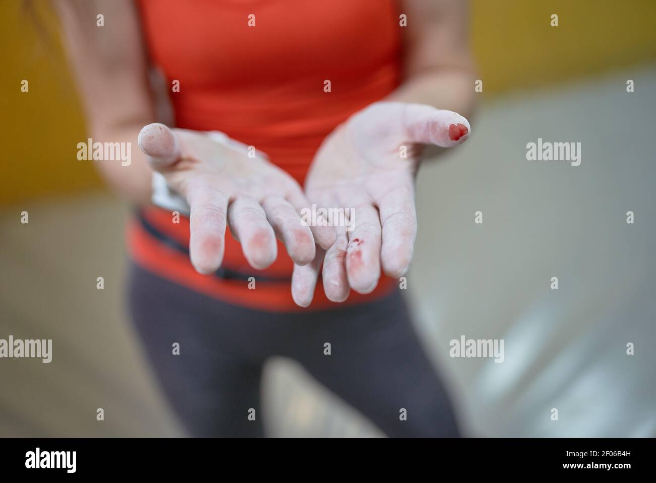 Crop unrecognizable female in sportswear demonstrating hands in chalk ...
