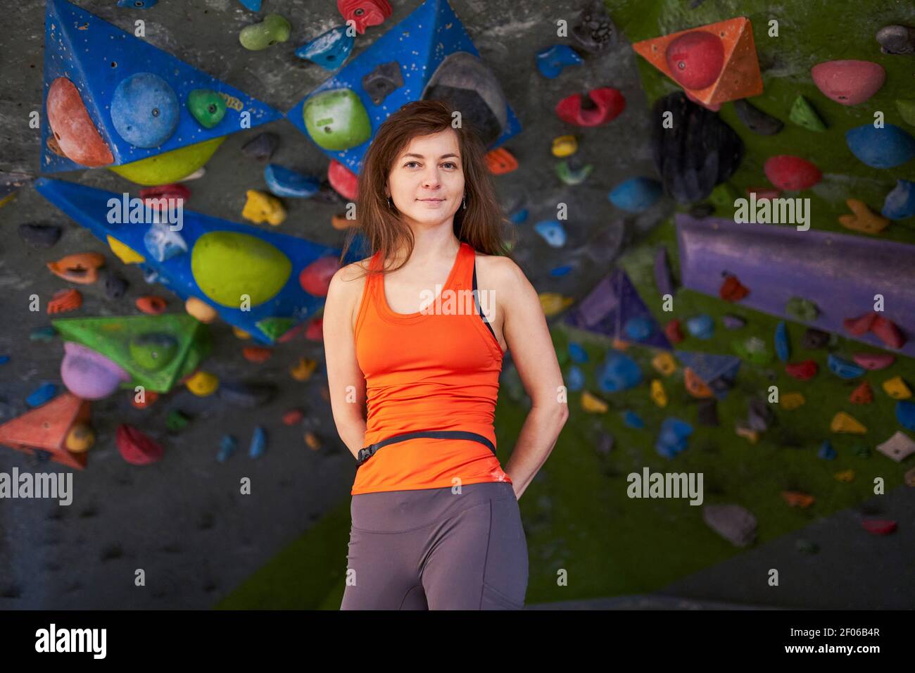 Charming strong Woman in sportswear holding hands behind back while ...