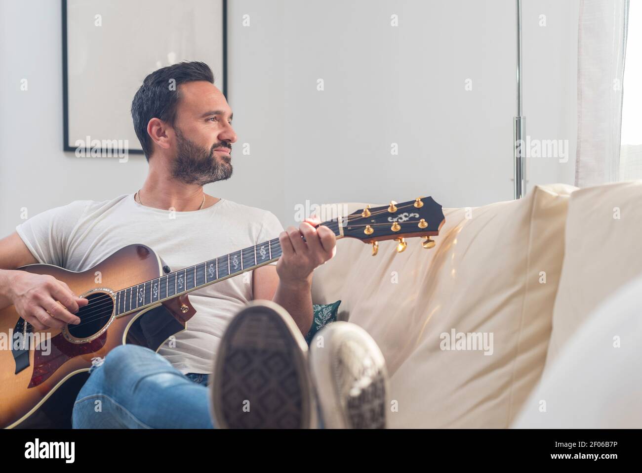 Full body of adult ethnic male musician in casual clothes relaxing on ...