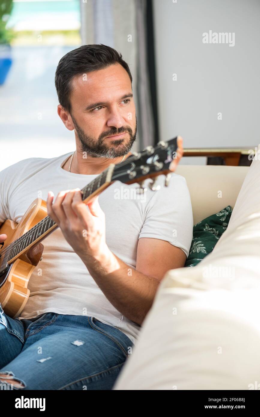 Adult ethnic male musician in casual clothes relaxing on comfortable ...