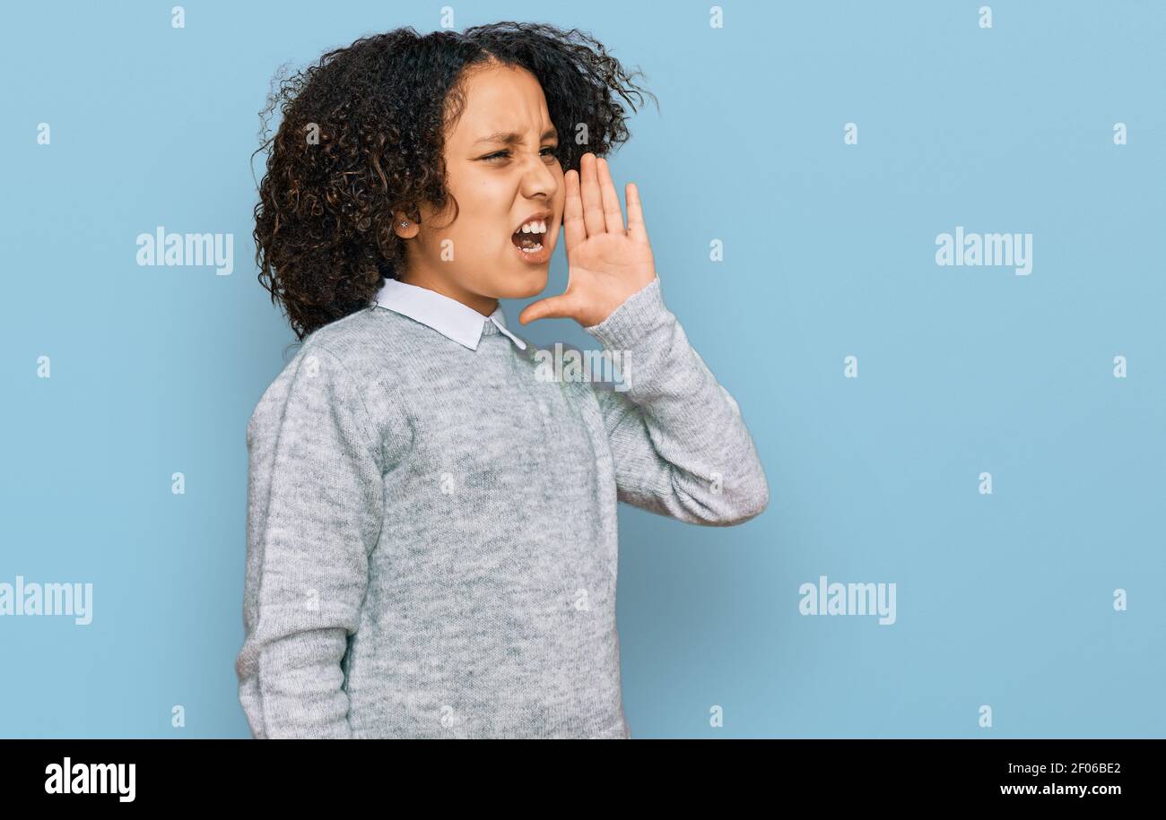 Young little girl with afro hair wearing casual clothes shouting and ...