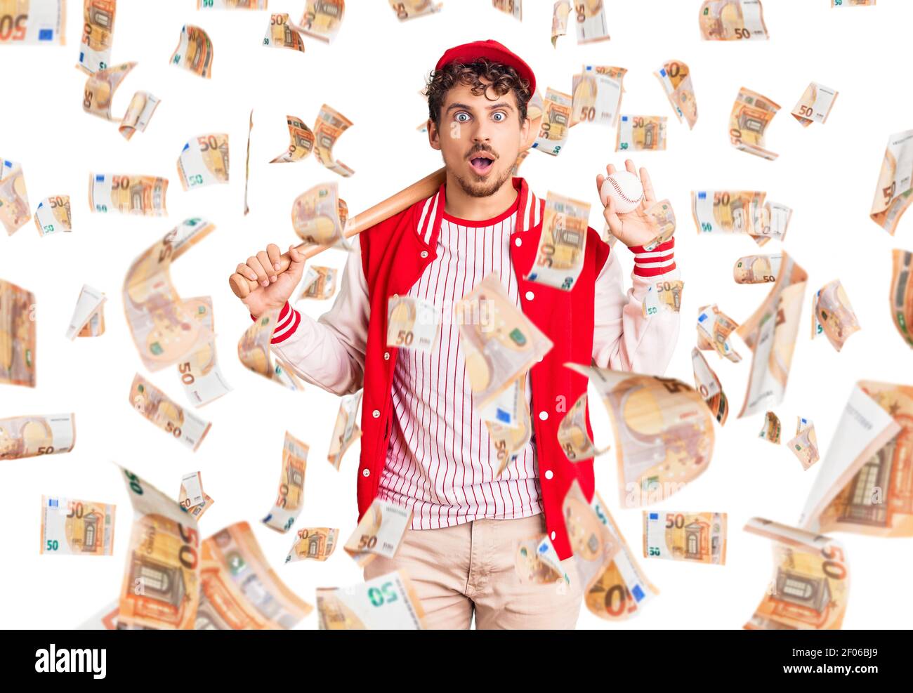 Young handsome man with curly hair playing baseball holding bat and ...