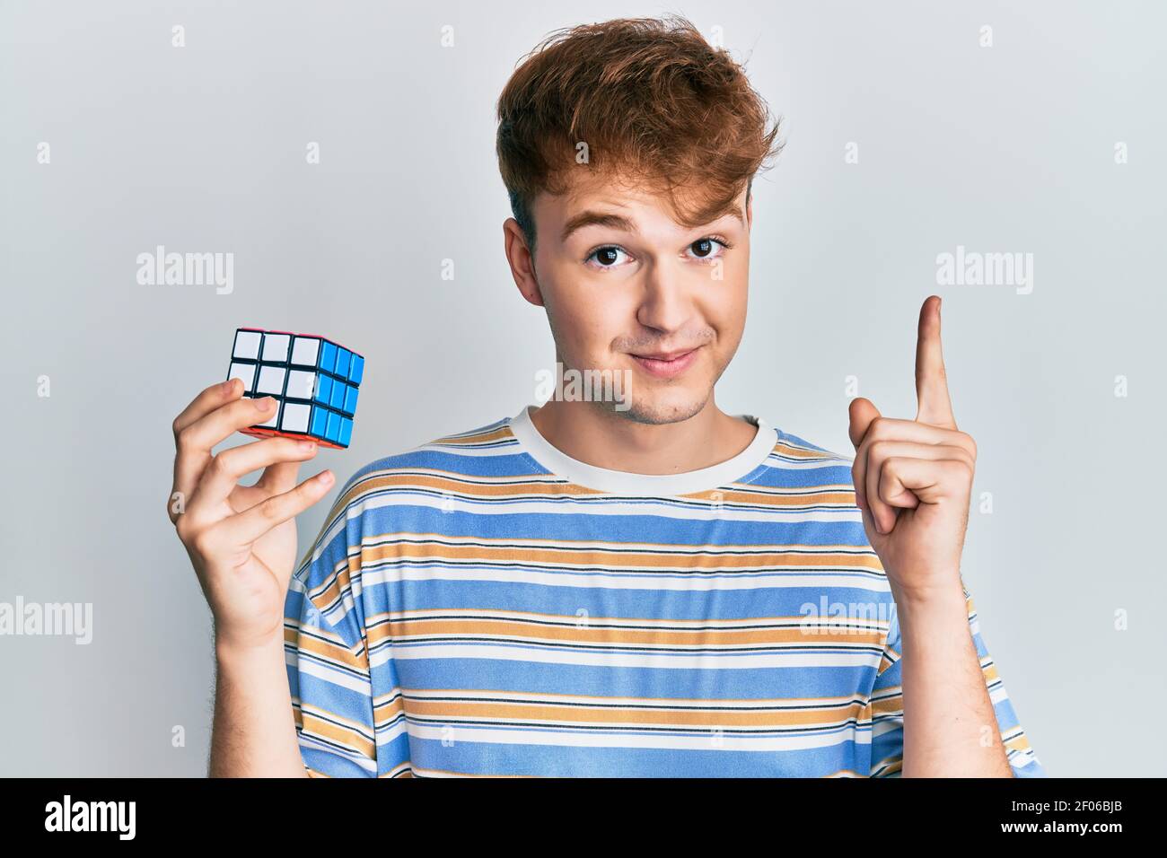 Young caucasian man playing colorful puzzle cube intelligence game ...