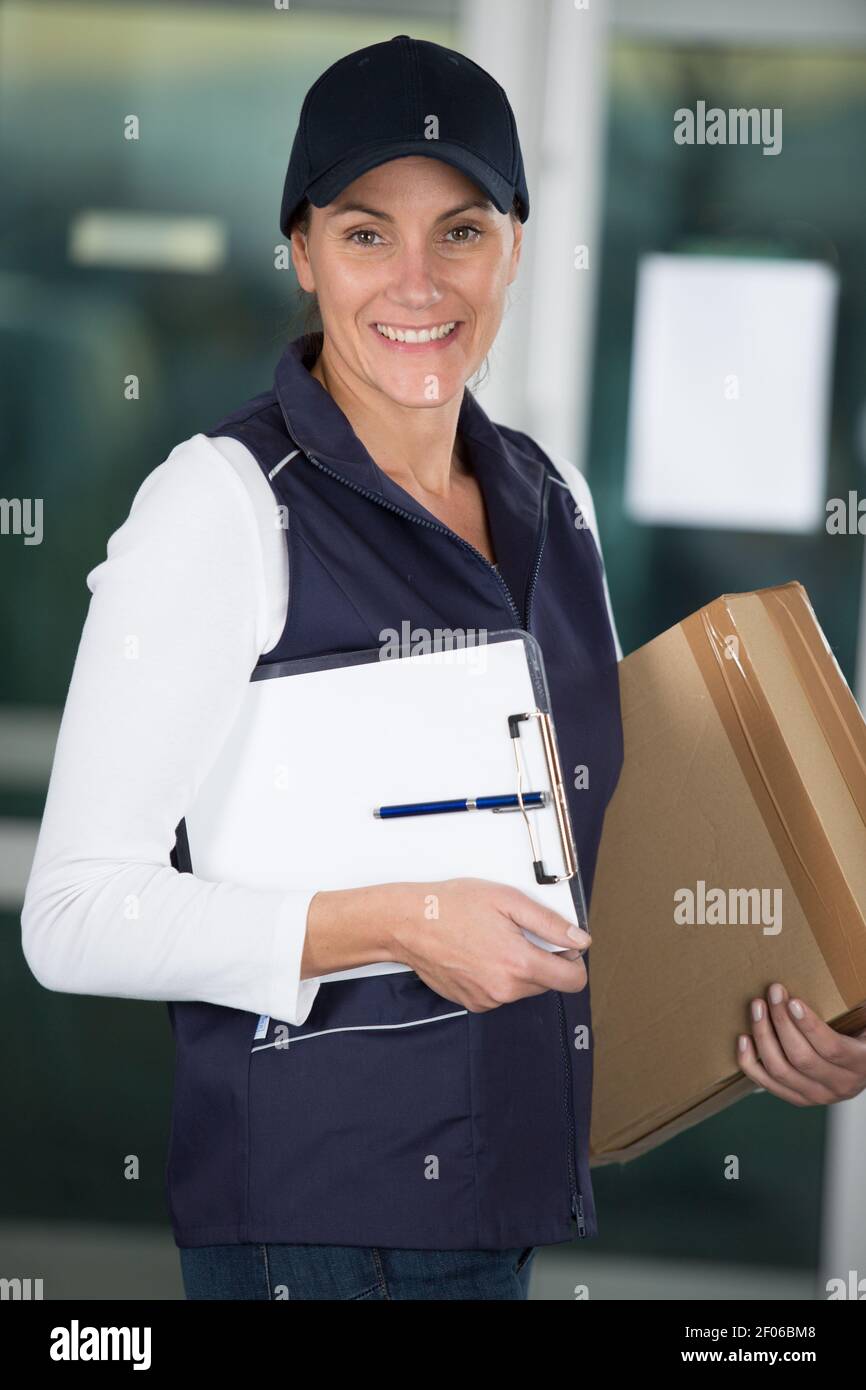 happy female delivery service with clipboard Stock Photo - Alamy