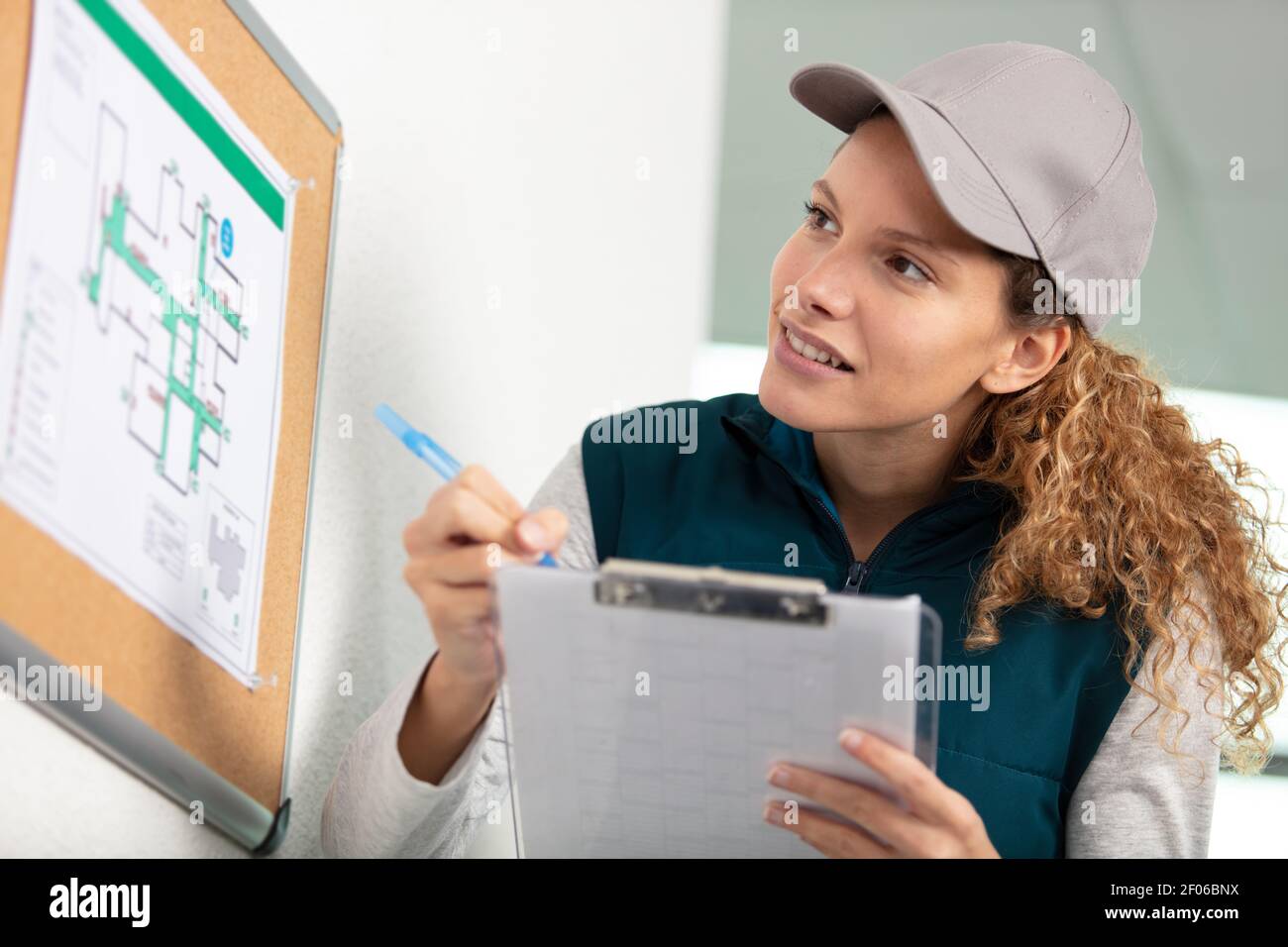 beautiful handywoman checking building safety map Stock Photo - Alamy