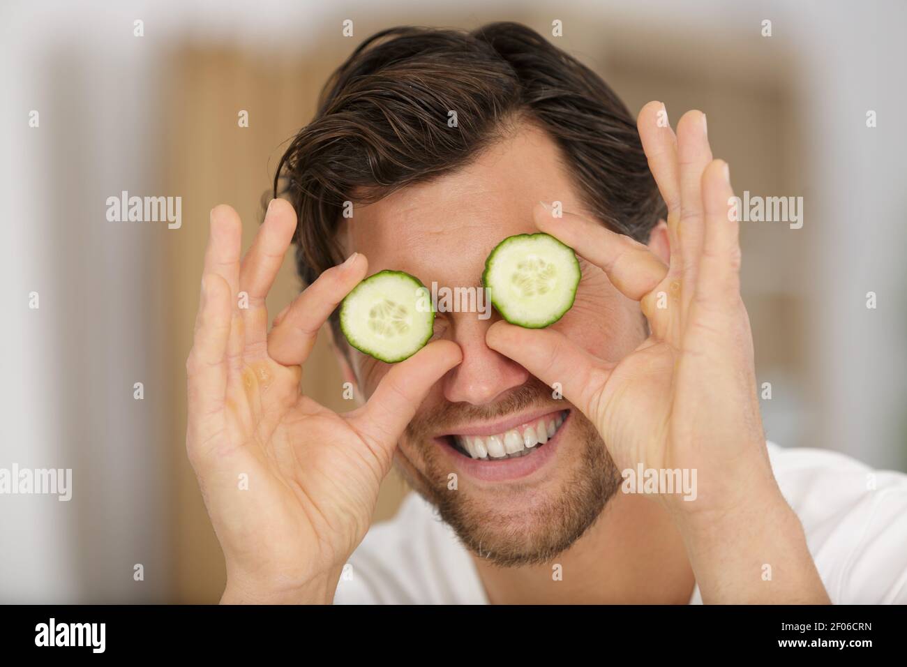 playful man holding slices of cucumber over his eyes Stock Photo - Alamy
