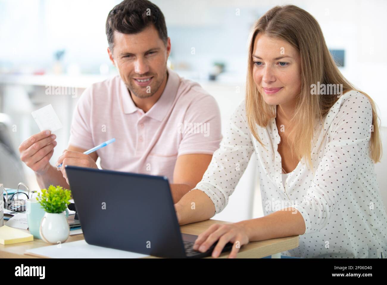 portrait of family couple looking attentively into screen of laptop ...