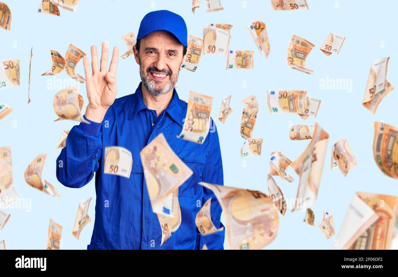 Middle age handsome man wearing mechanic uniform showing and pointing ...