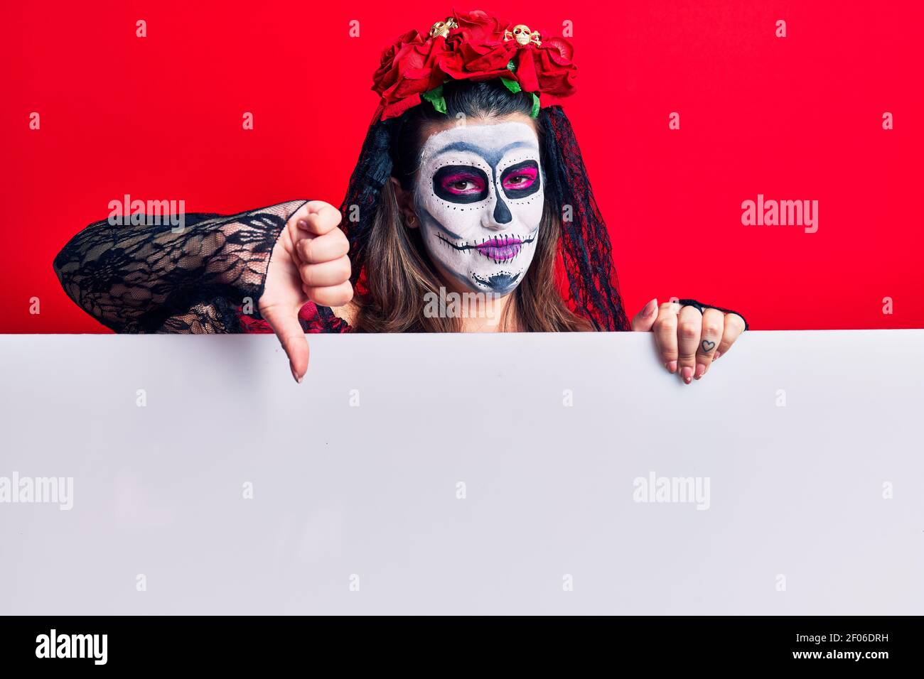 Young woman wearing day of the dead costume holding blank empty banner ...