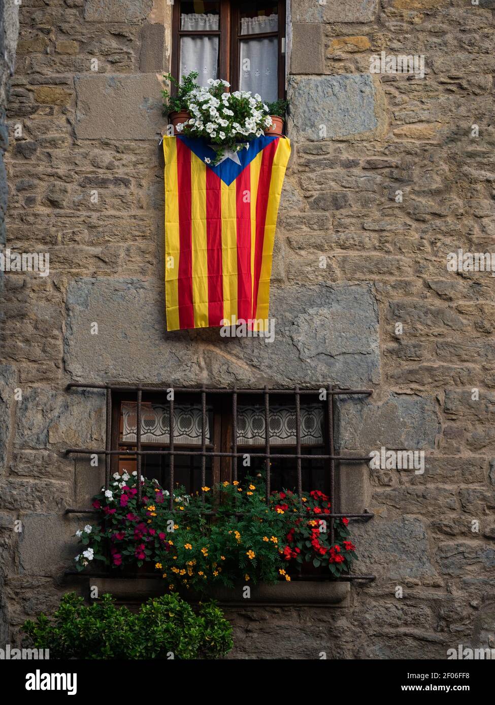 Medieval architecture stone rock buildings flower Senyera flag in ...