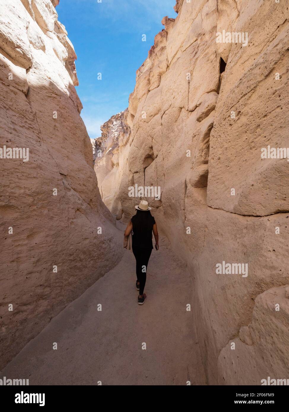 Female tourist walking through Quebrada de Culebrillas volcanic rock ...