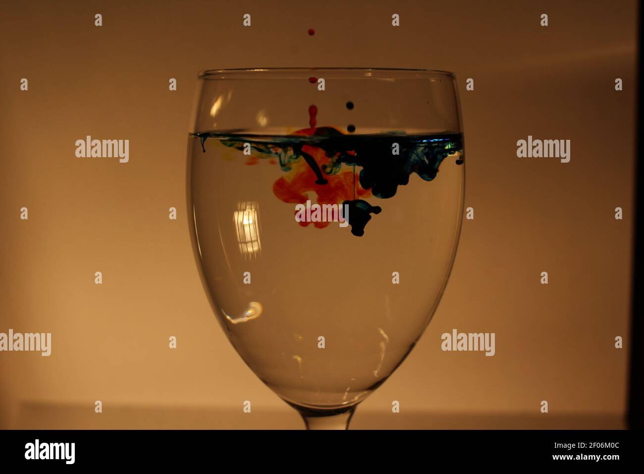 Freeze frame of food coloring dropped into glass Stock Photo - Alamy