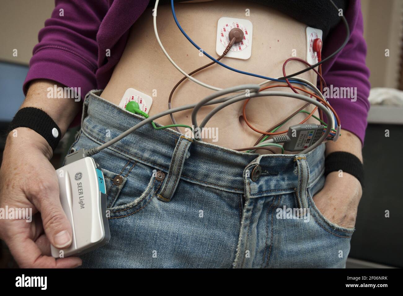 A woman wears a General Electric brand Seer Light Holter, an ambulatory ...