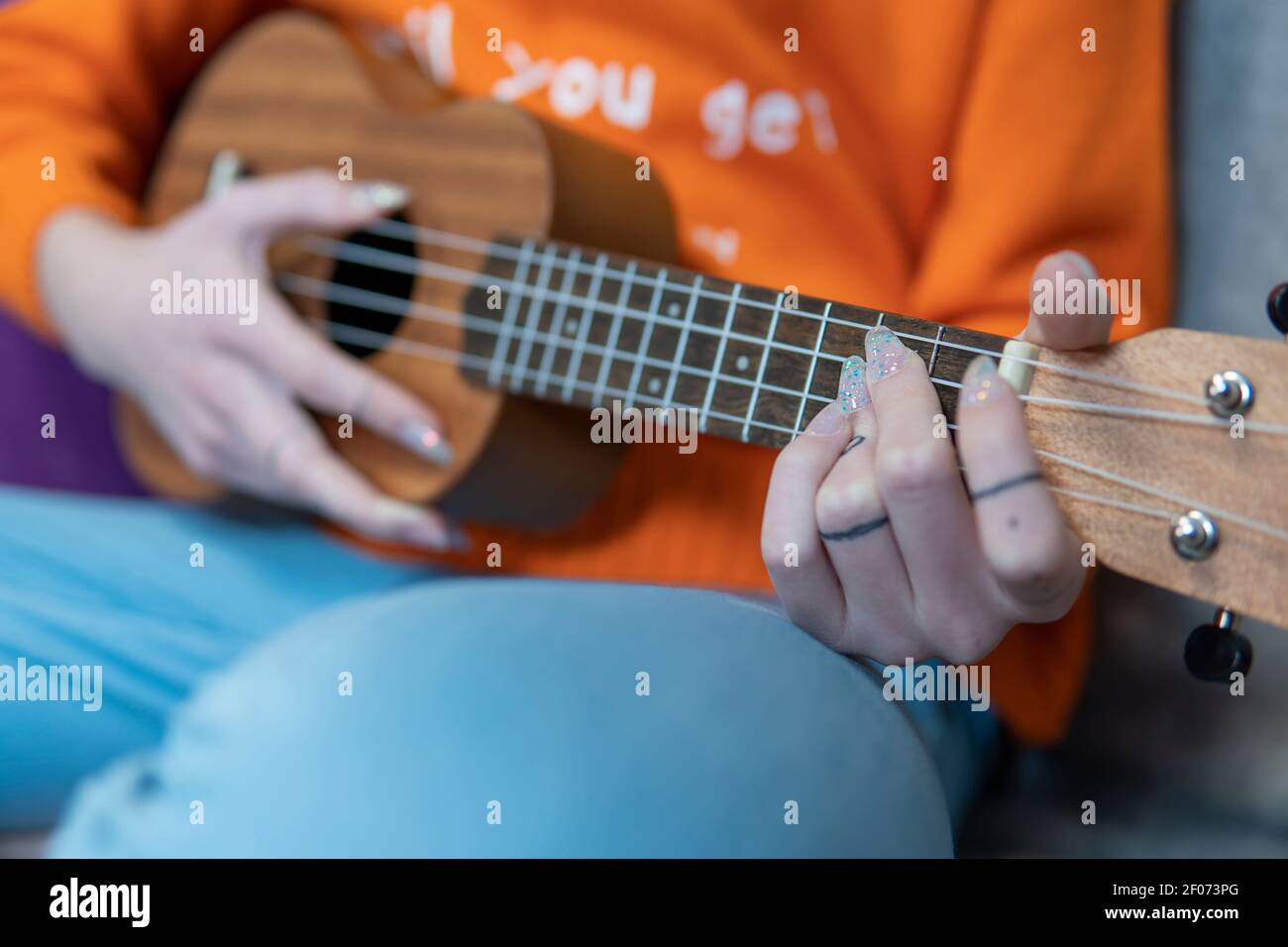 close-up. Girl's hands play Hawaiian musical instrument ukulele Stock ...